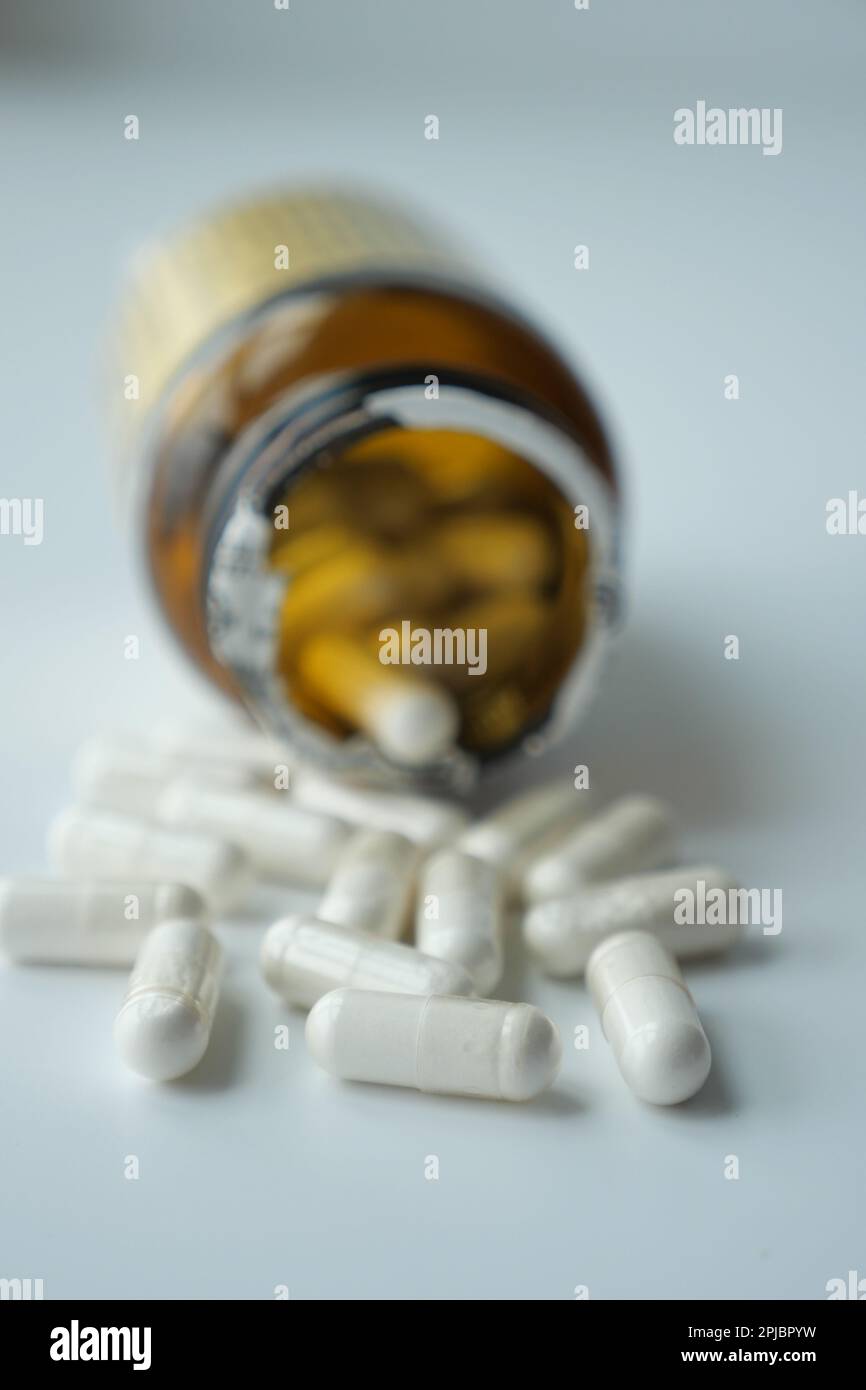 herbal medicine capsule dropping on white Stock Photo - Alamy