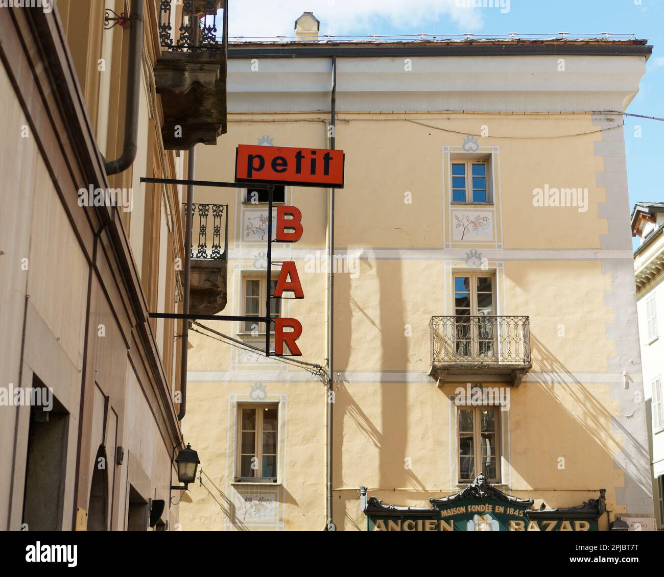 Orange bar sign in a quaint pastel coloured area with peach coloured ...
