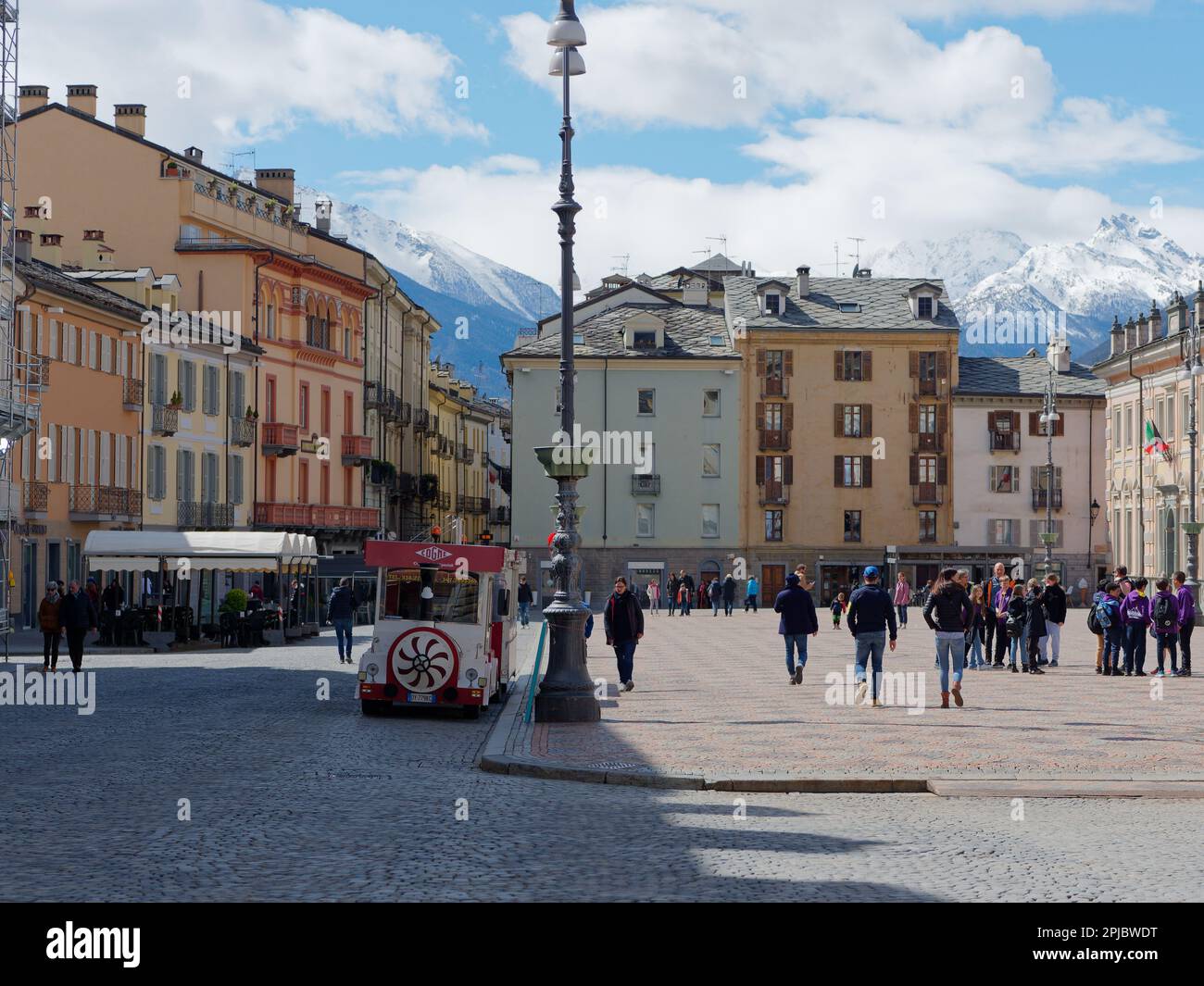 Crowds and tour bus that looks like a train in the main square in Aosta ...