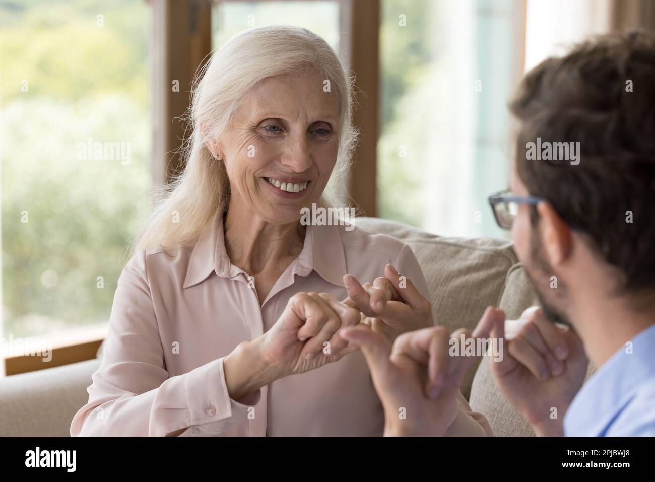 Old lady with hearing disability speaking sign language to man Stock ...