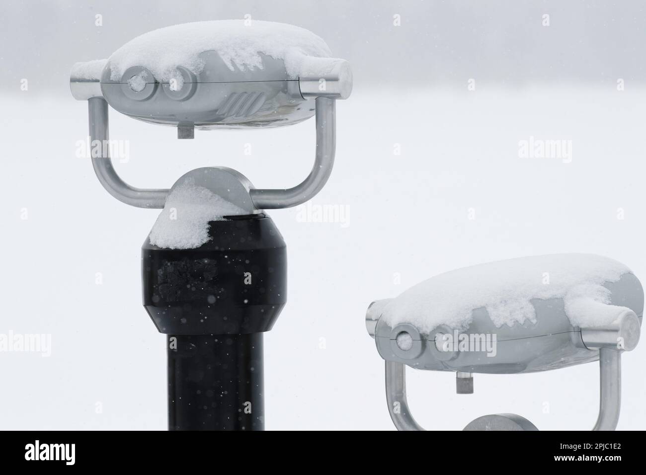 Stationary telescope or tower viewer during a light snowfall and low ...