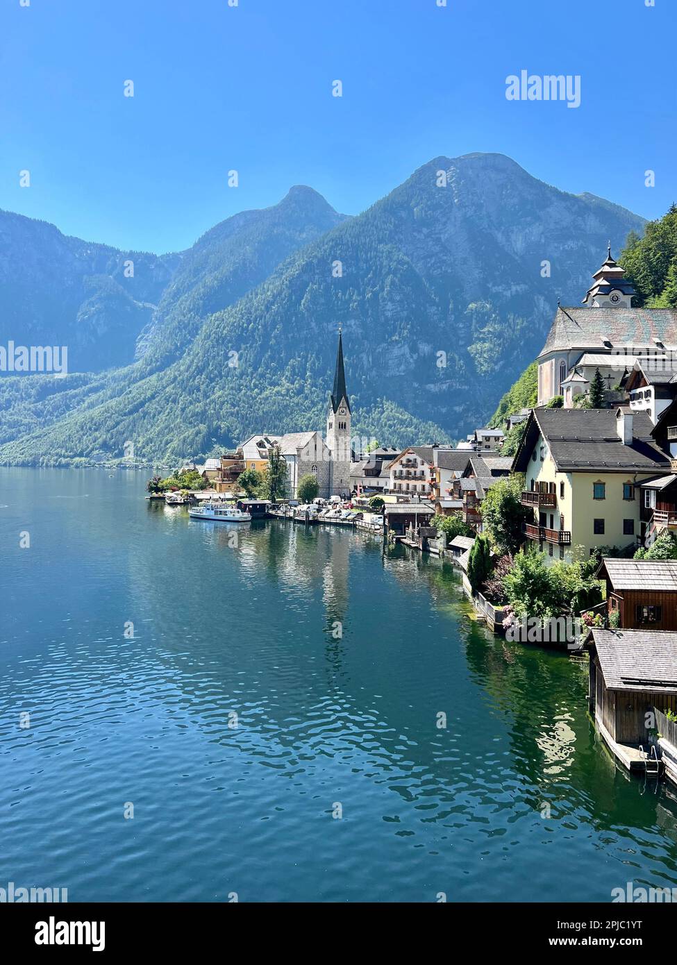 The picturesque town and tranquil lake, with majestic mountains in the ...