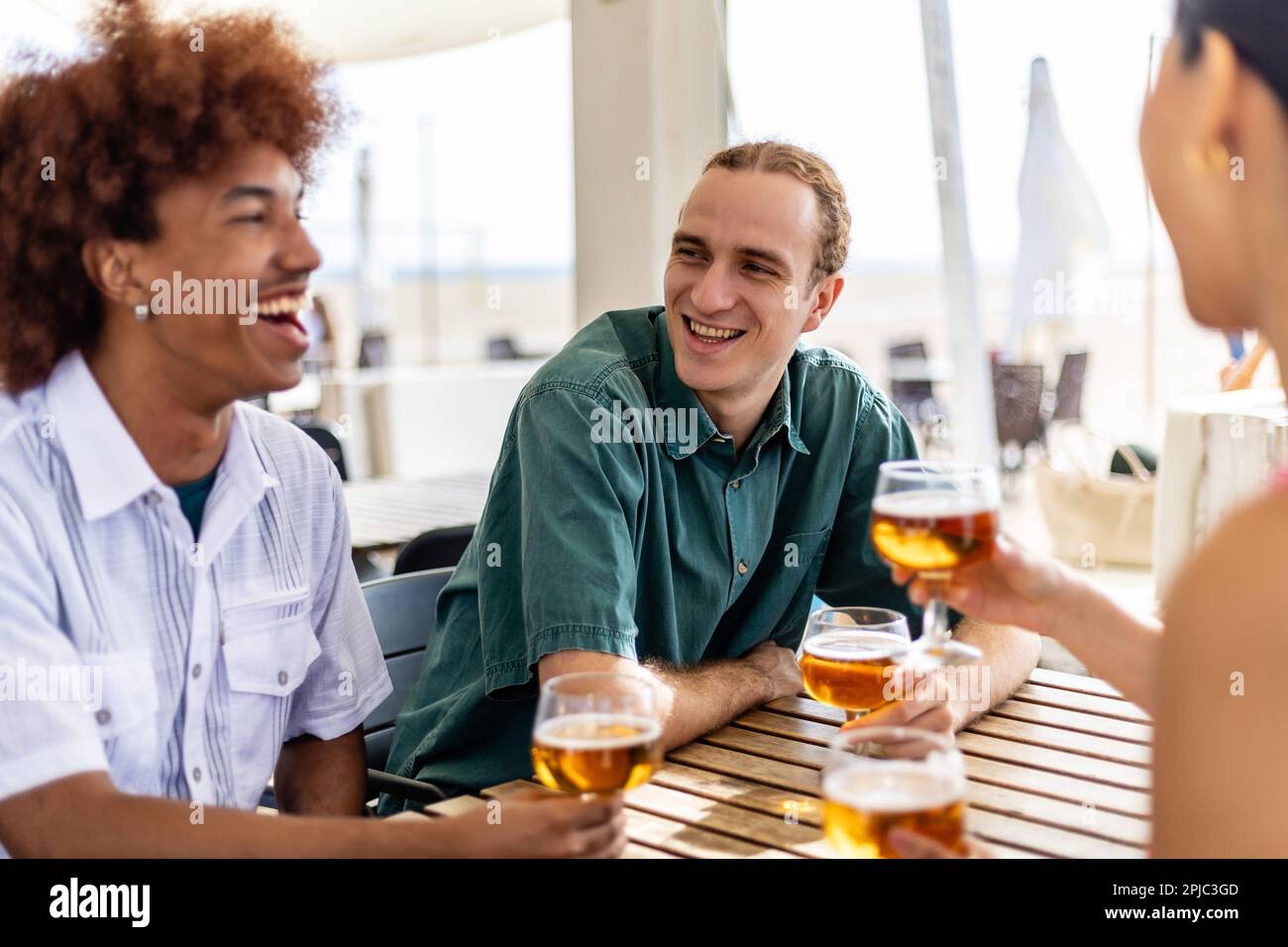 Young group of multiracial people drinking cold beer at beach bar ...