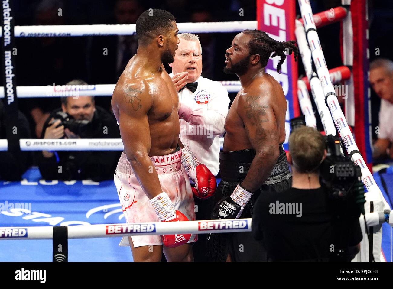 Referee Marcus McDonnell (centre) speaks to Anthony Joshua and Jermaine ...