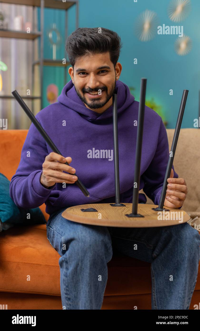 Happy indian man finishing assembling furniture at home. Successful ...
