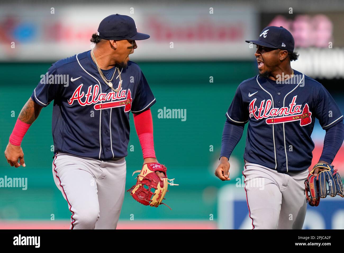 Atlanta Braves' Orlando Arcia, left, and Ozzie Albies react as the run ...