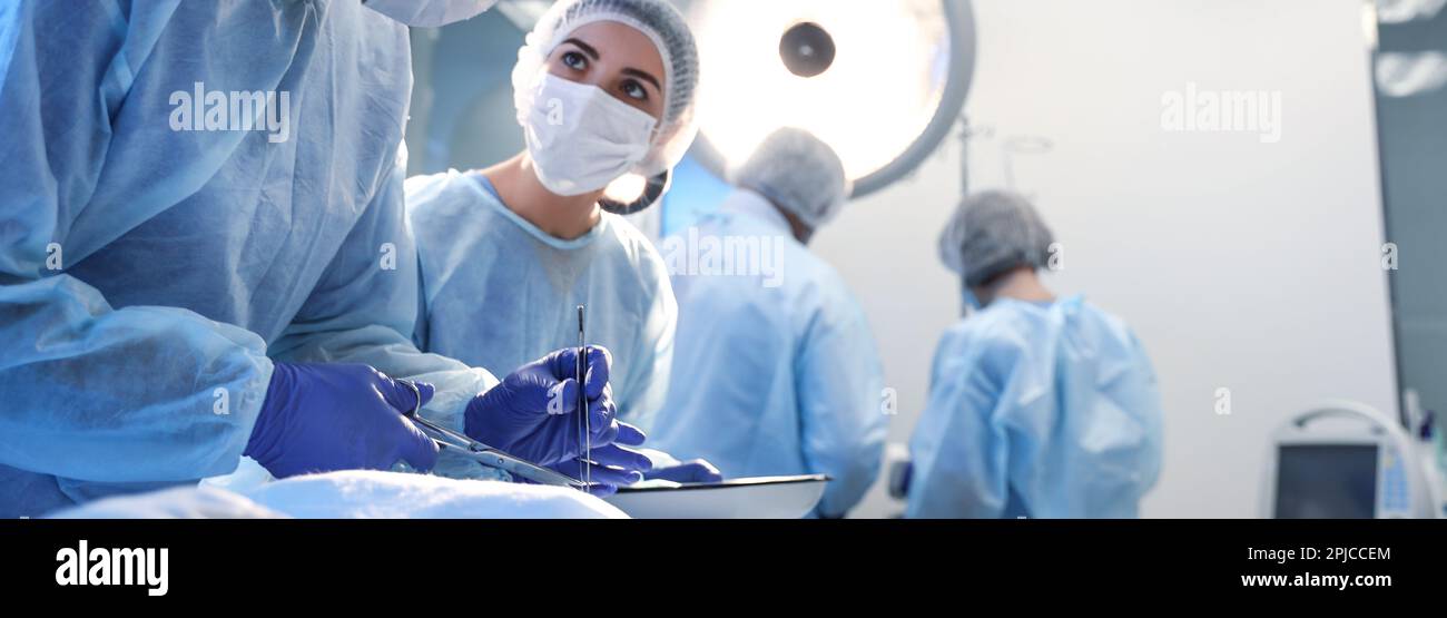 Team of professional surgeons performing operation in clinic, space for ...