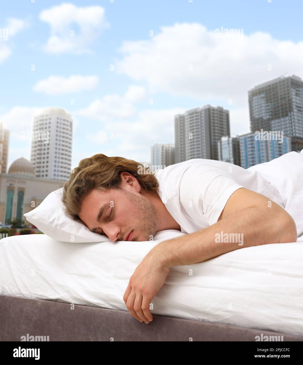 Man sleeping in bed and beautiful view of cityscape on background. Good ...