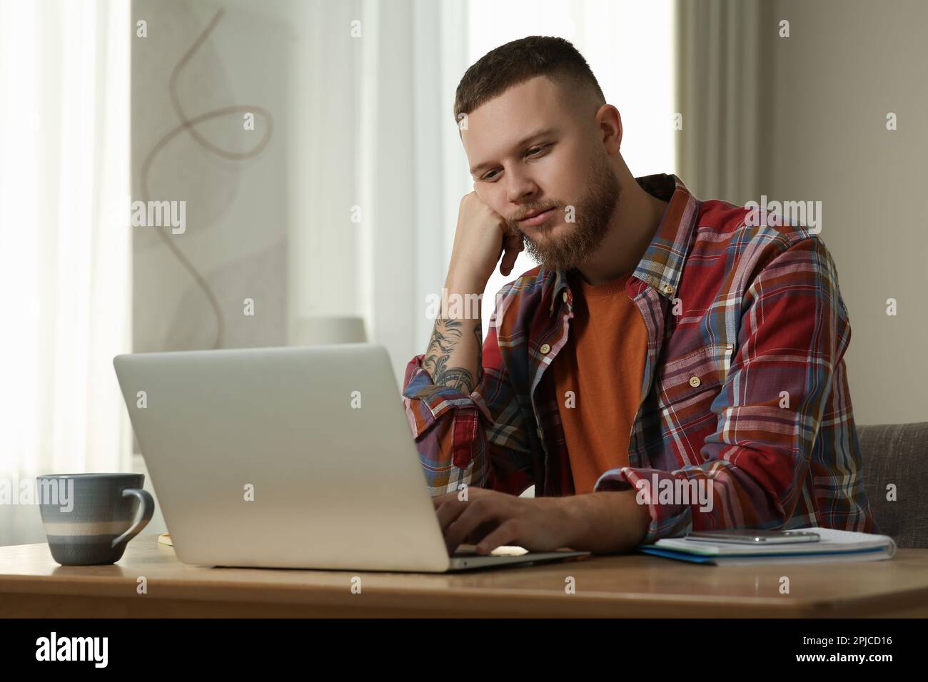 Online test. Man studying with laptop at home Stock Photo - Alamy
