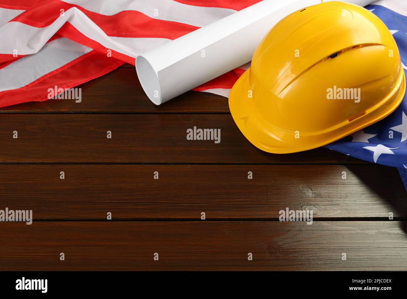 Yellow protective hard hat, construction drawing and American flag on ...