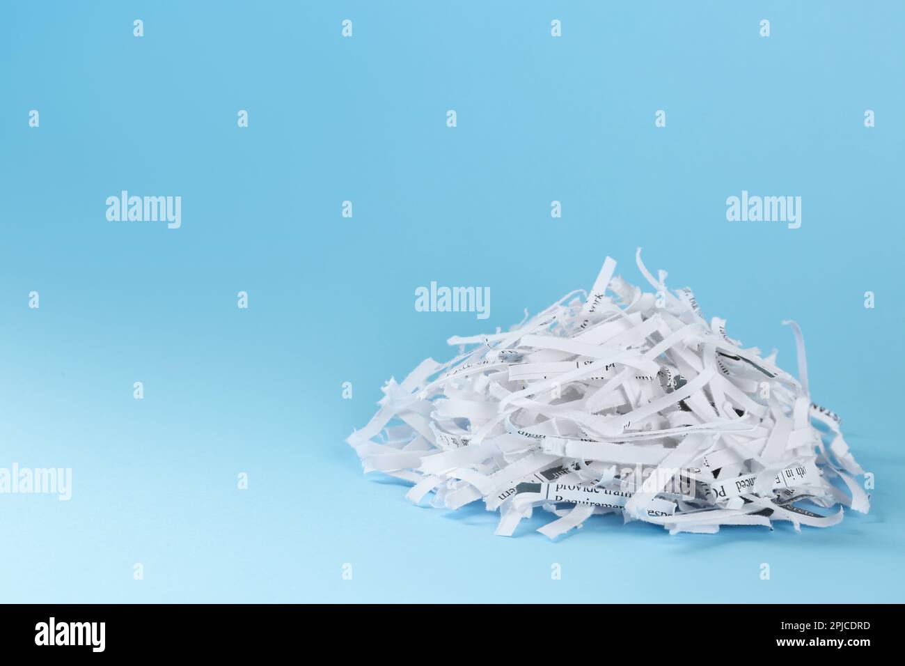 Heap of shredded paper strips on light blue background, space for text ...