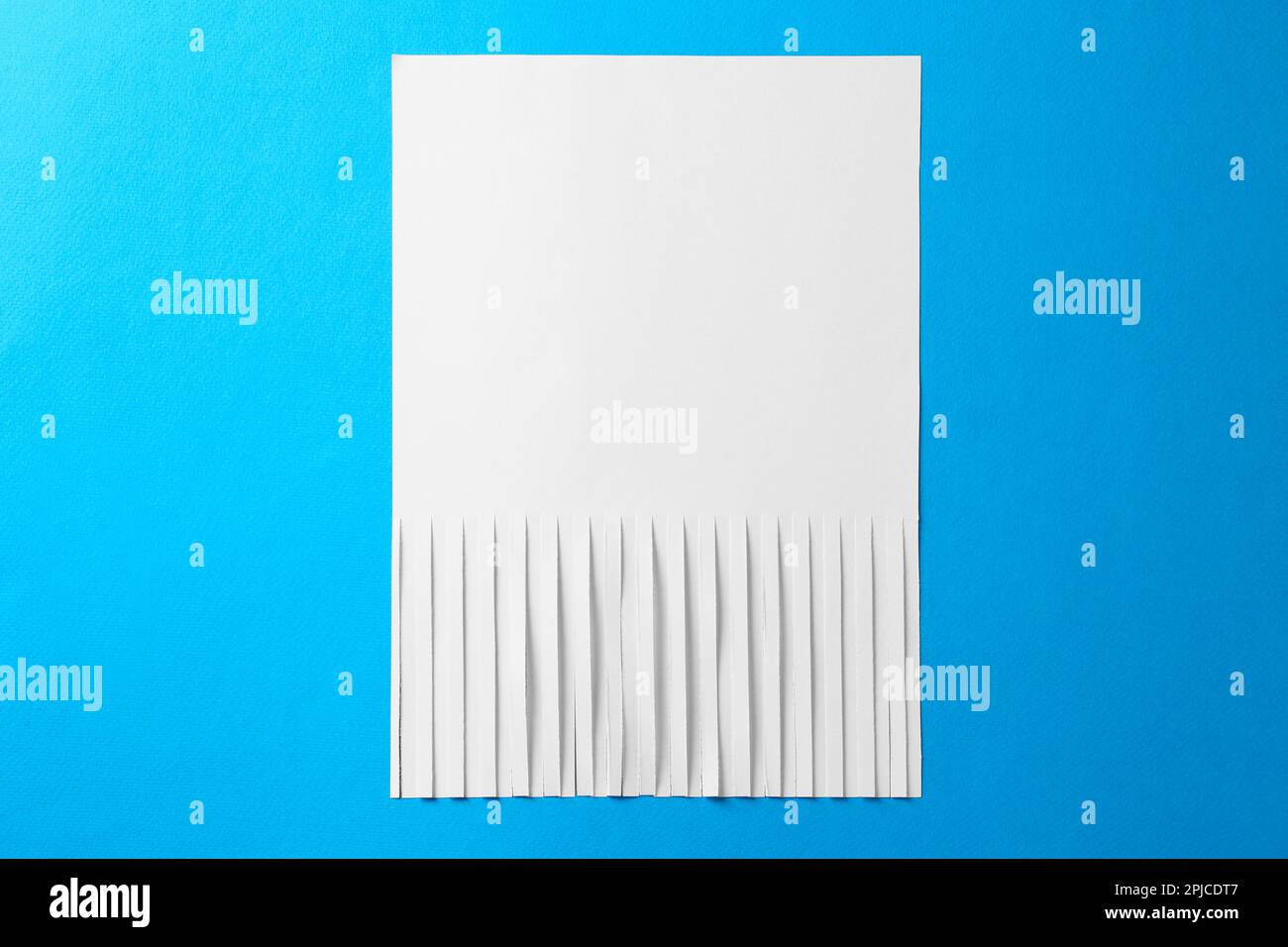 Half shredded sheet of paper on light blue background, top view Stock ...