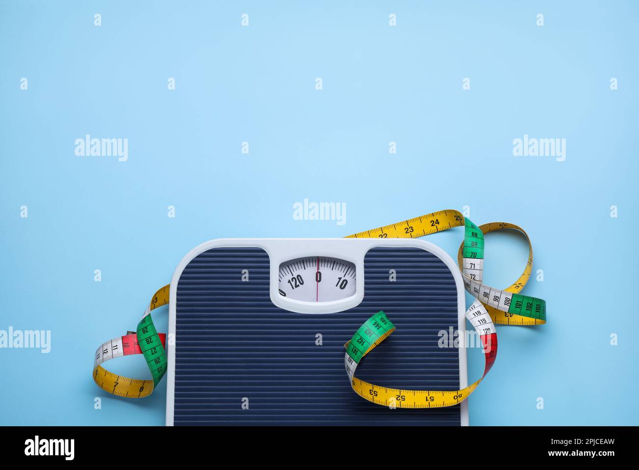 Scales and measuring tape on light blue background, flat lay. Space for ...