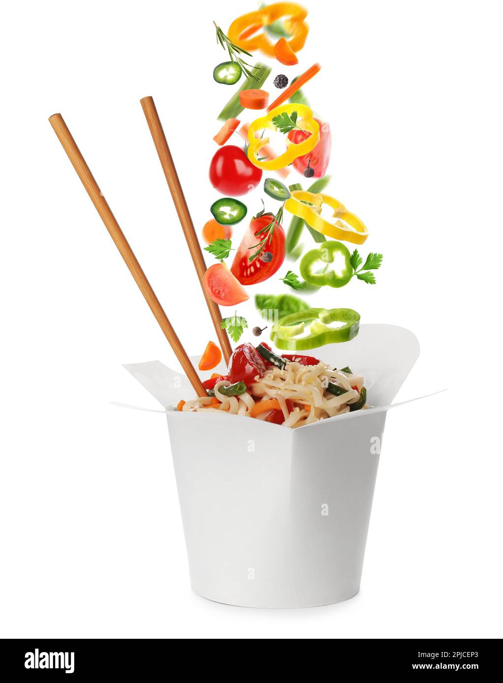 DIfferent fresh ingredients falling into box of wok noodles on white ...