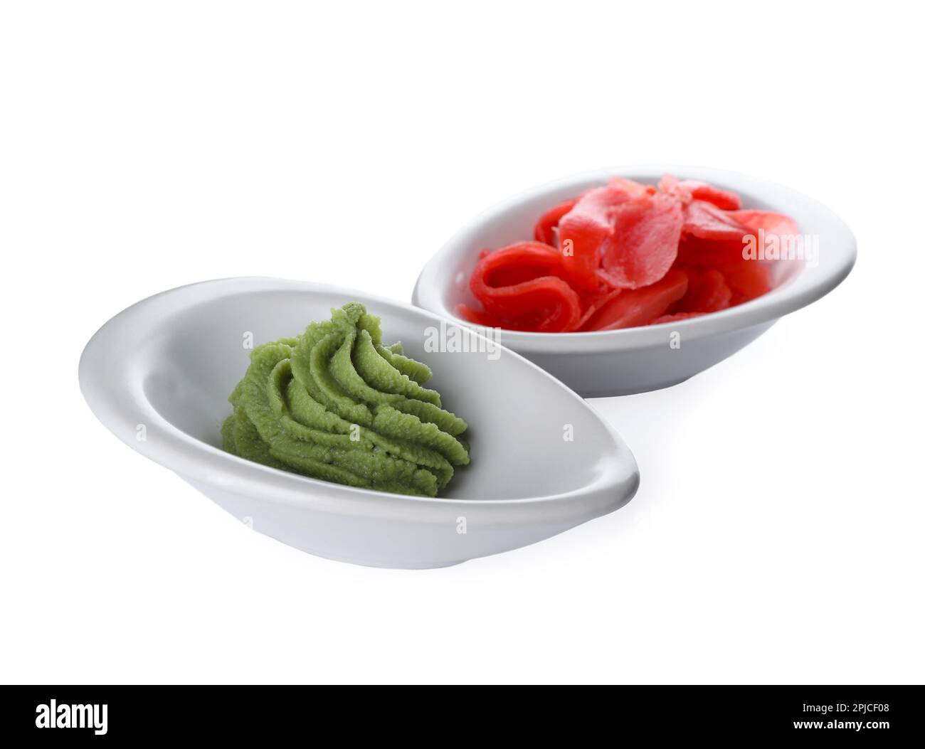 Bowls with swirl of wasabi paste and pickled ginger on white background ...