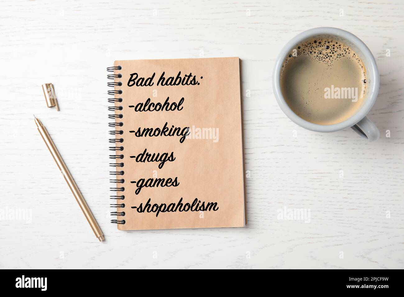 Notebook with list of bad habits and cup of coffee on white wooden ...