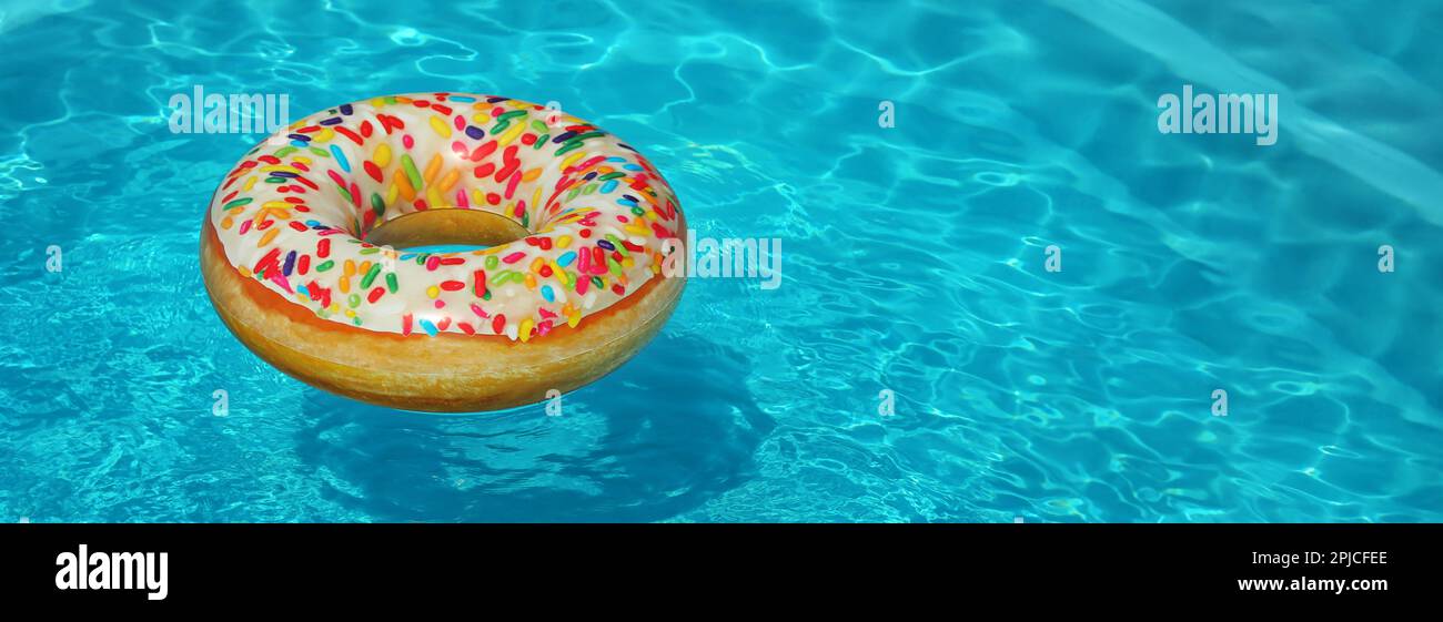 Bright inflatable doughnut ring floating in swimming pool on sunny day ...