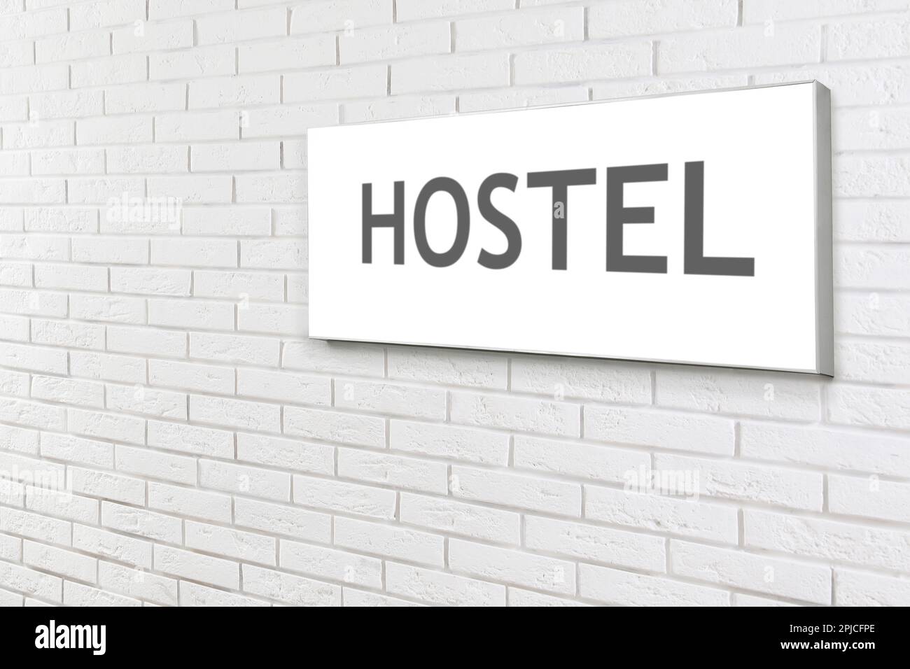 HOSTEL sign board on white brick wall Stock Photo - Alamy