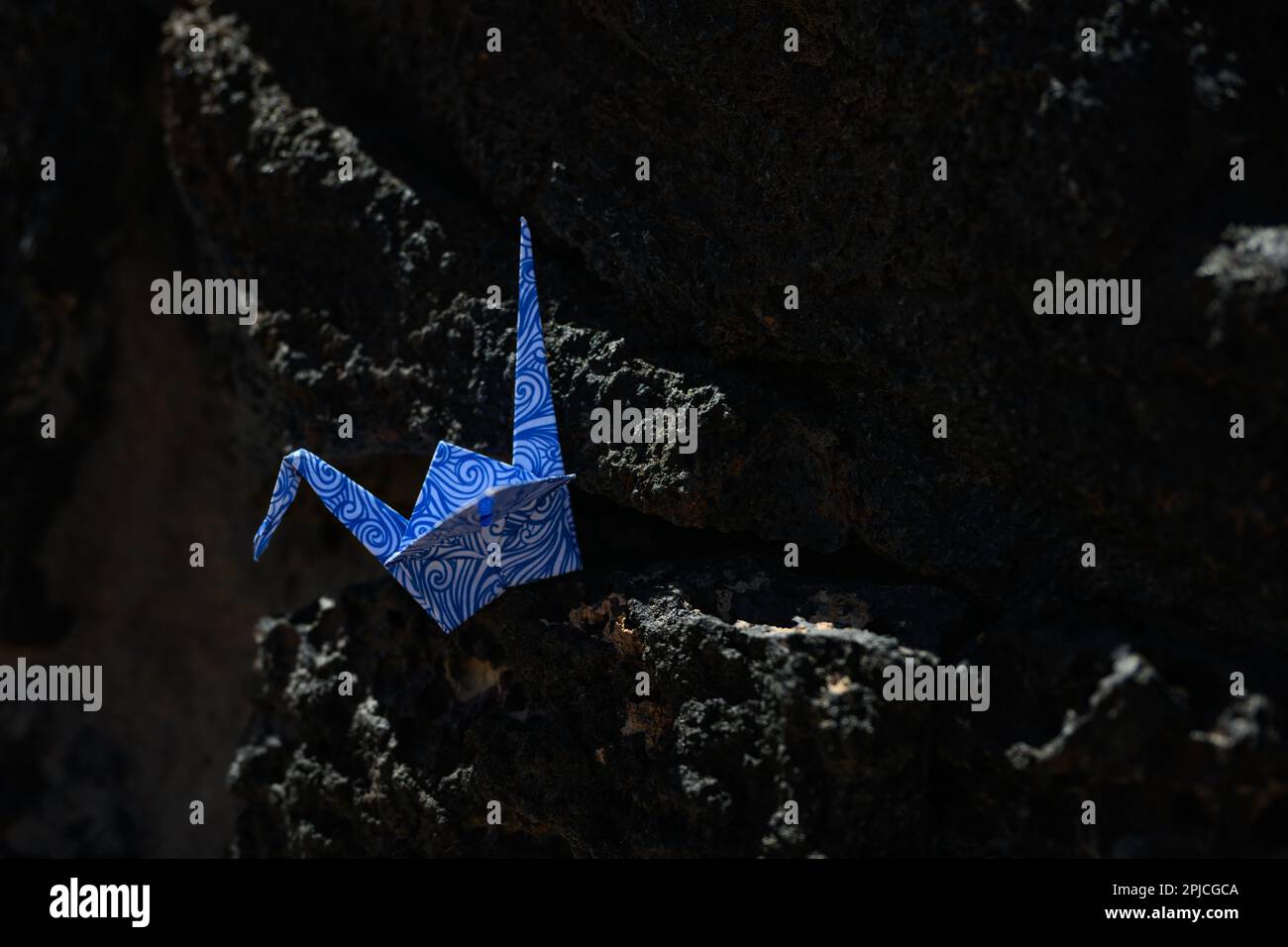 An oragami swan is placed on the black rock obelisk monument that marks ...