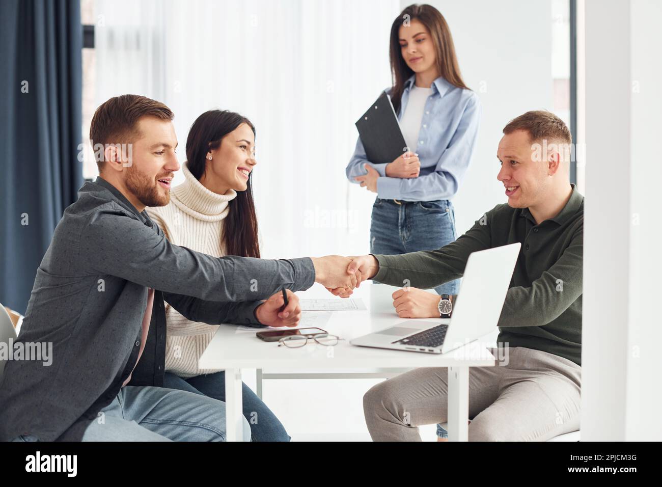 Four people works in the office by sitting by the table indoors Stock ...