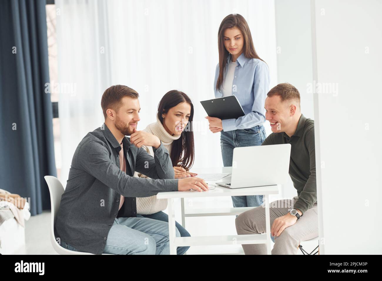 Four people works in the office by sitting by the table indoors Stock ...