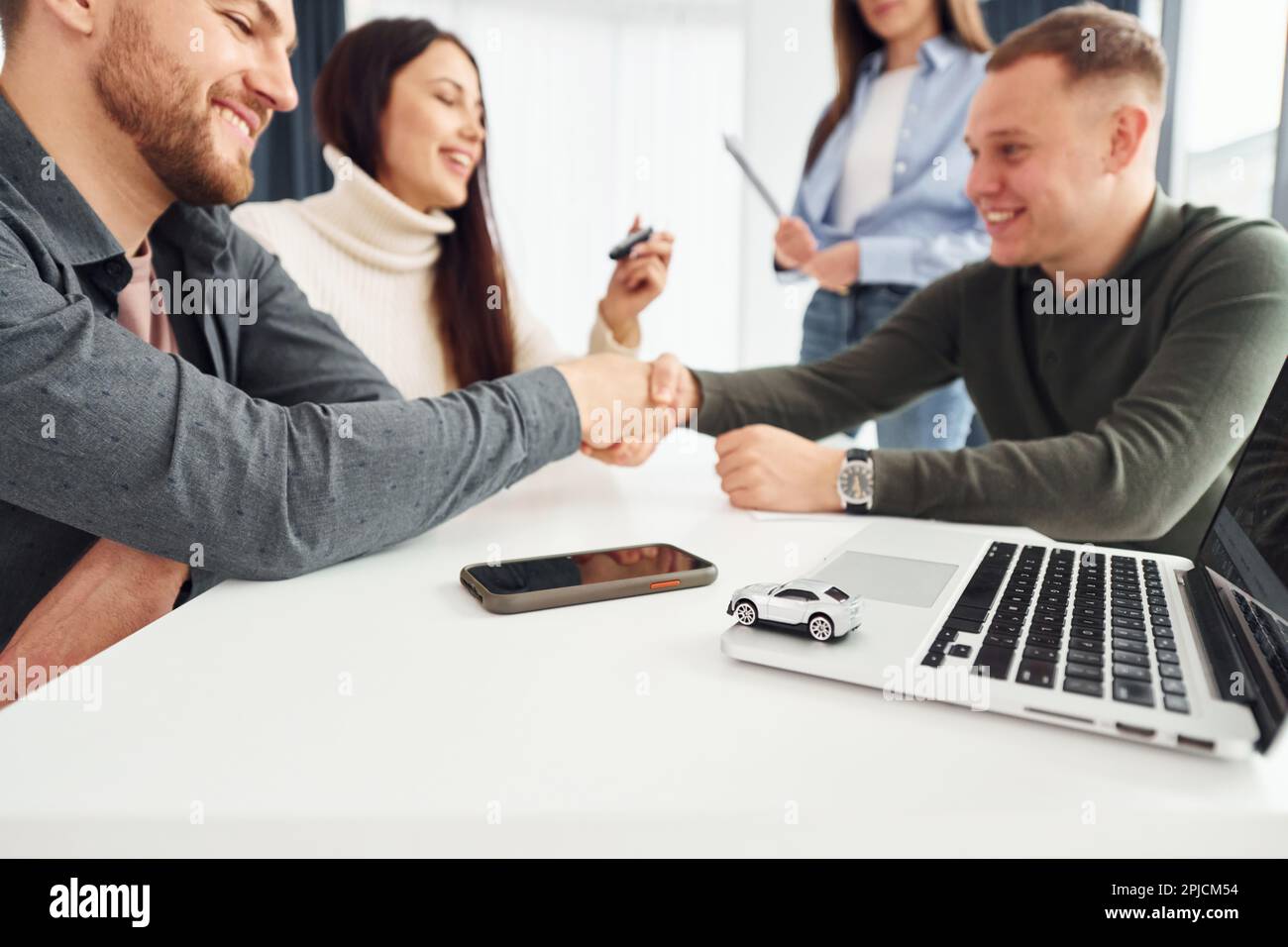 Doing handshake. Group of people works in the office by sitting by the ...