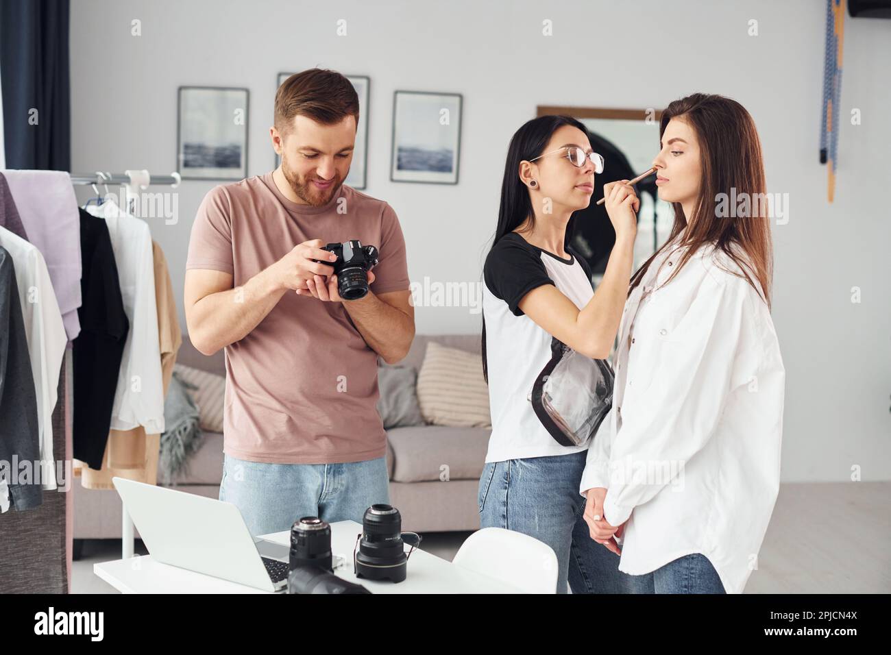 Preparing model. Photographers works indoors in their studio at daytime ...