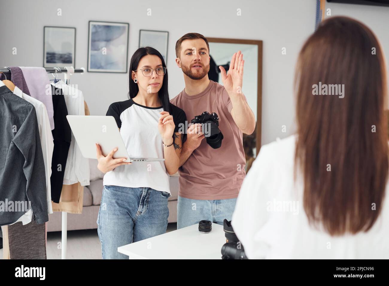 Preparing model. Photographers works indoors in their studio at daytime ...