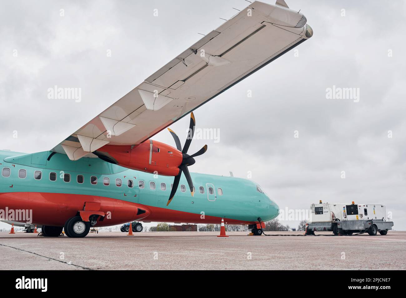 Orange and blue colored. Turboprop aircraft parked on the runway at ...