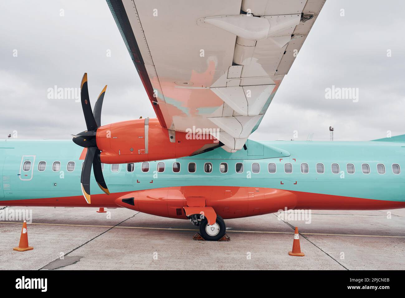 Orange and blue colored. Turboprop aircraft parked on the runway at ...