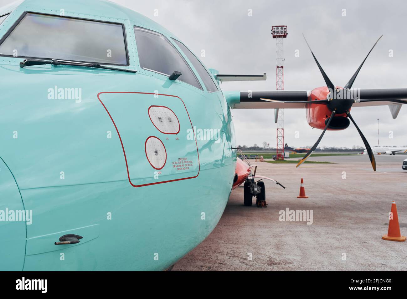 Orange and blue colored. Turboprop aircraft parked on the runway at ...