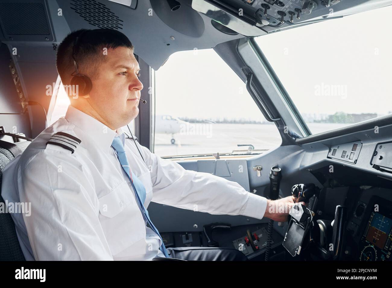 Side view. Pilot in formal wear sits in the cockpit and controls ...