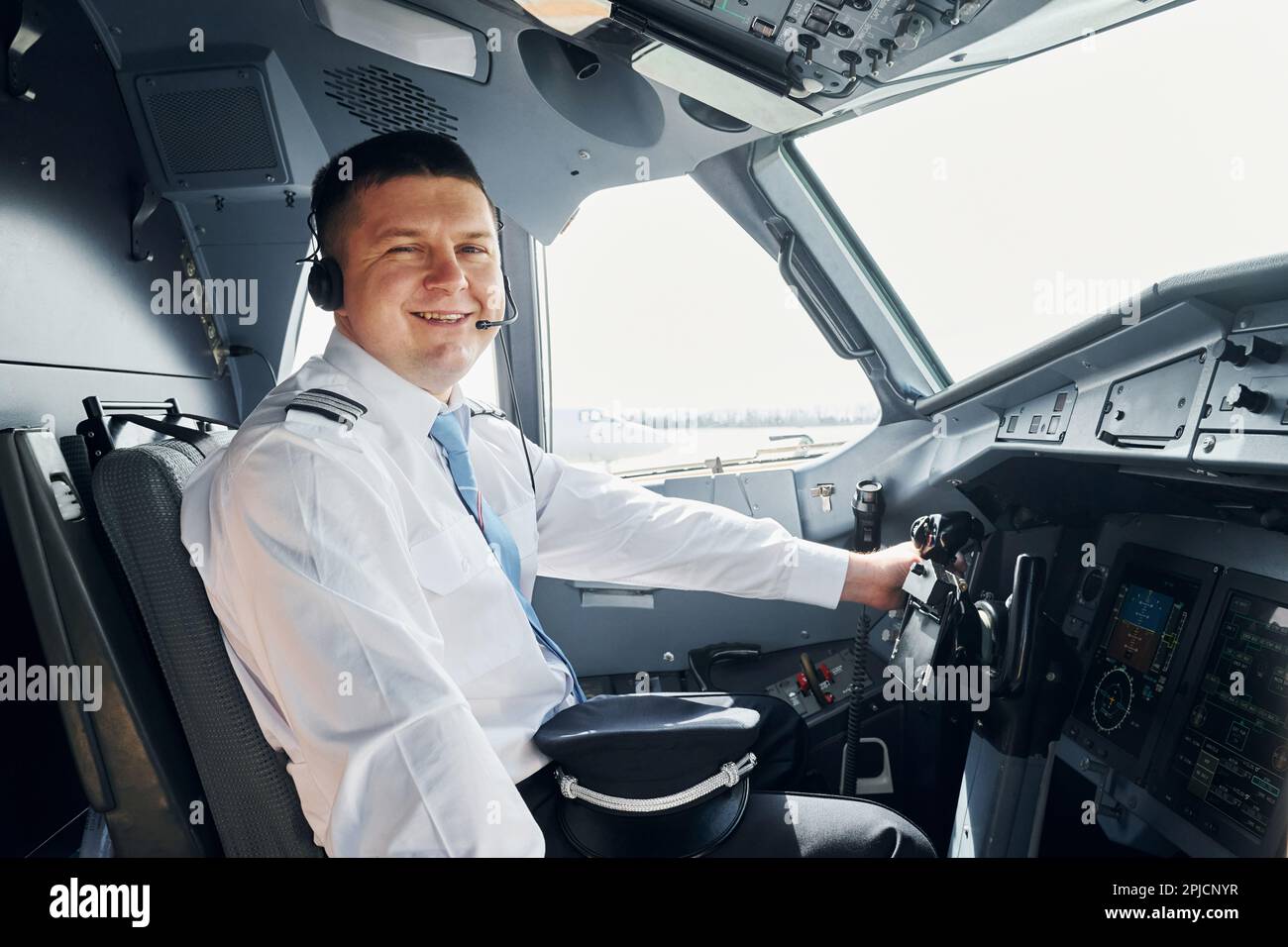 Side view. Pilot in formal wear sits in the cockpit and controls ...