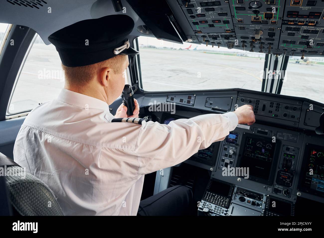 Pilot in formal wear sits in the cockpit and controls airplane Stock ...
