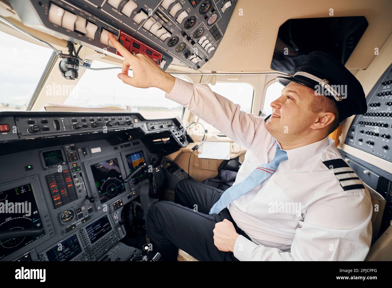 Professional worker. Pilot in formal wear sits in the cockpit and ...