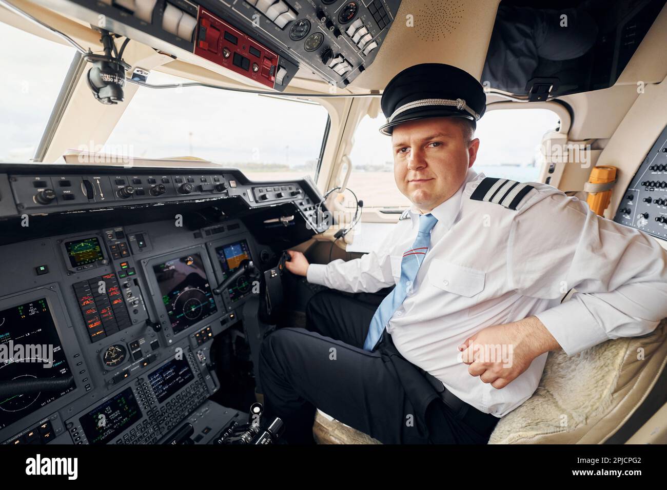 Professional worker. Pilot in formal wear sits in the cockpit and ...
