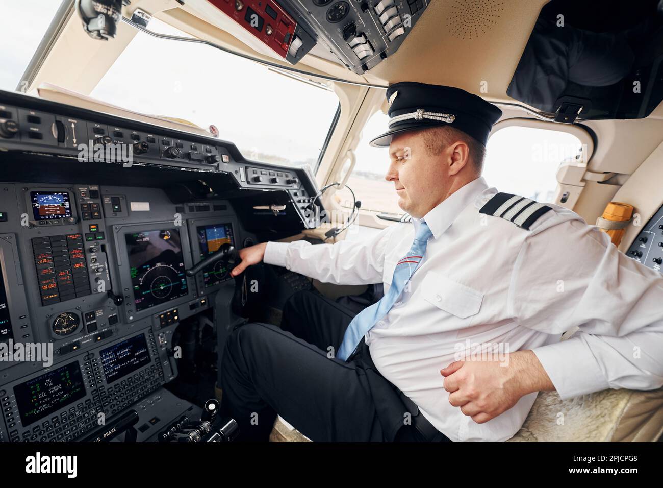 Professional worker. Pilot in formal wear sits in the cockpit and ...