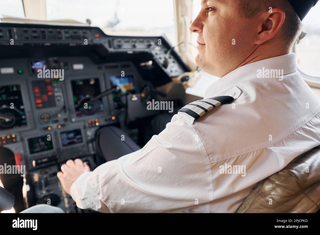 Calm atmosphere. Pilot in formal wear sits in the cockpit and controls ...