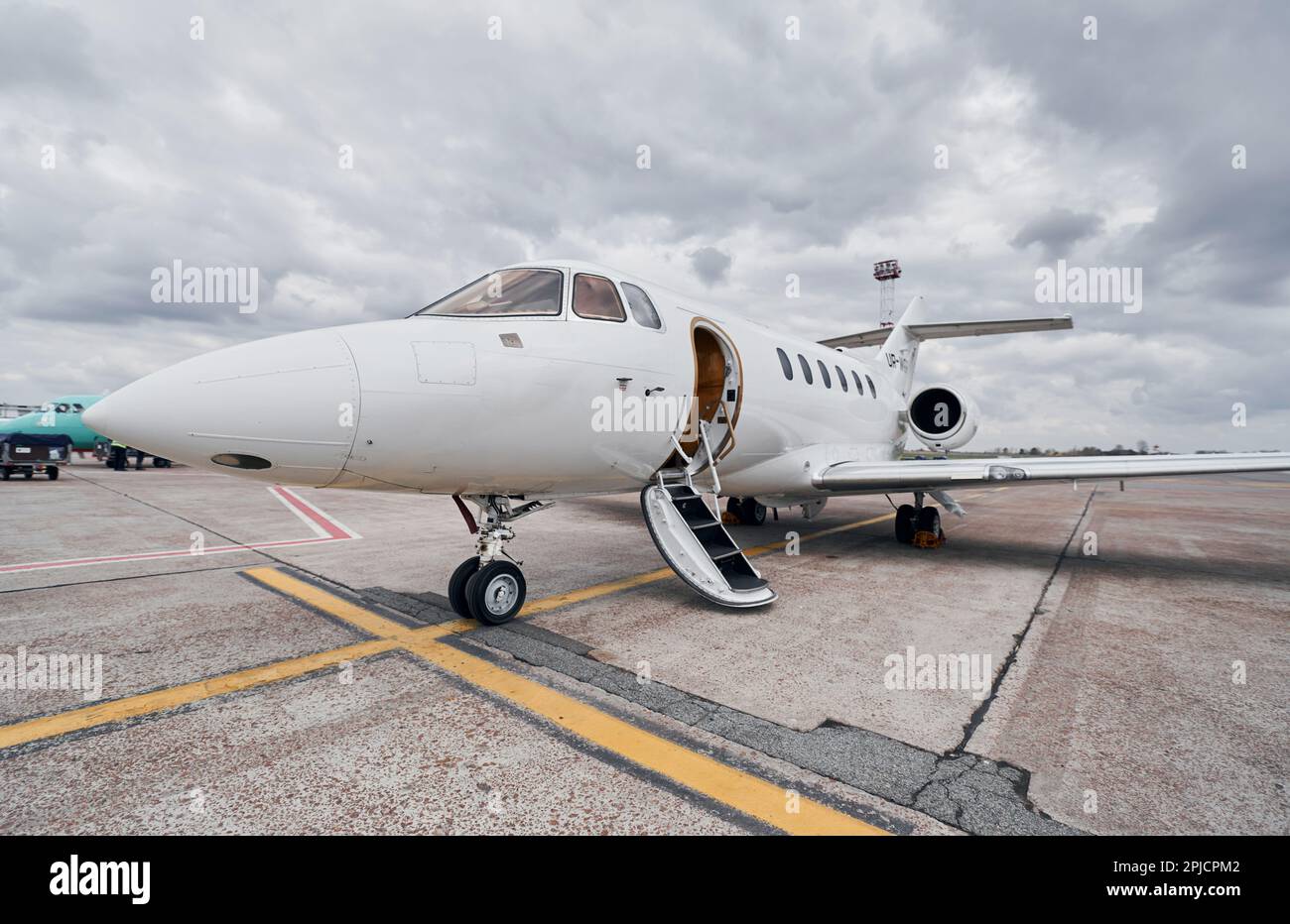 Cloudy weather. Turboprop aircraft parked on the runway at daytime ...
