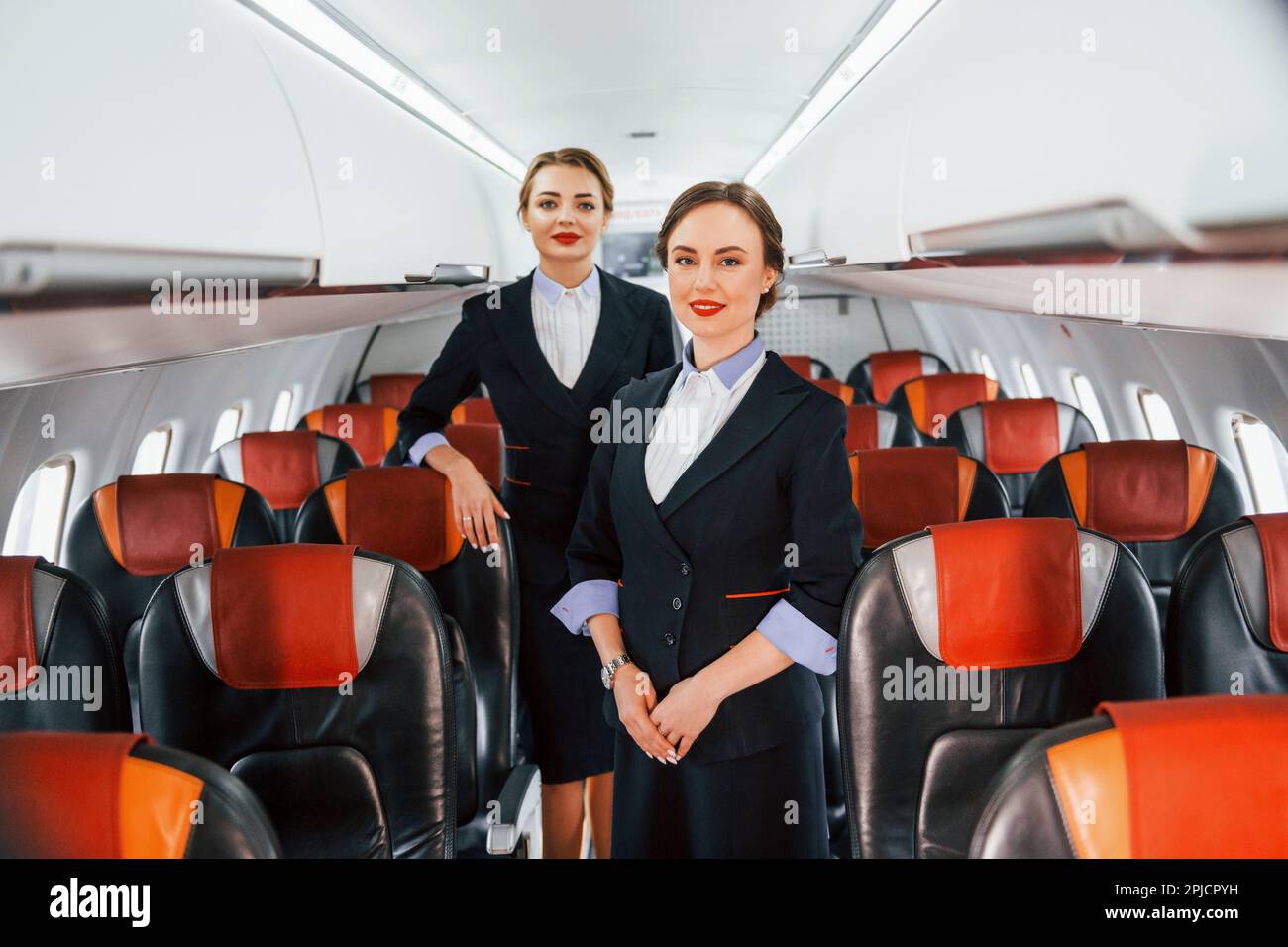 Two stewardess on the work in the passanger airplane Stock Photo - Alamy