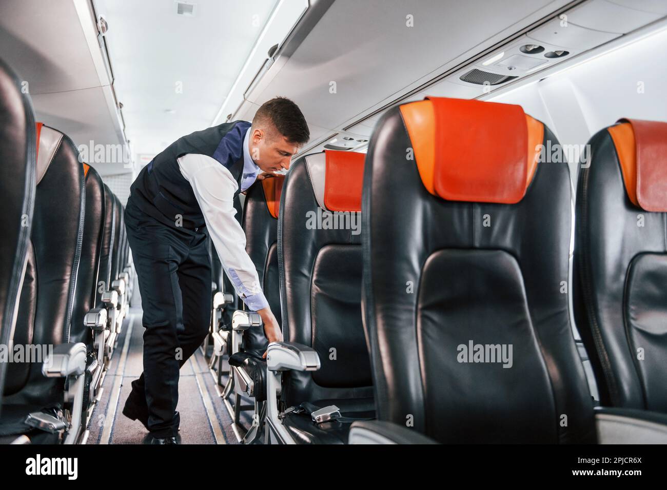 Young steward in uniform on the work in the passanger airplane Stock ...