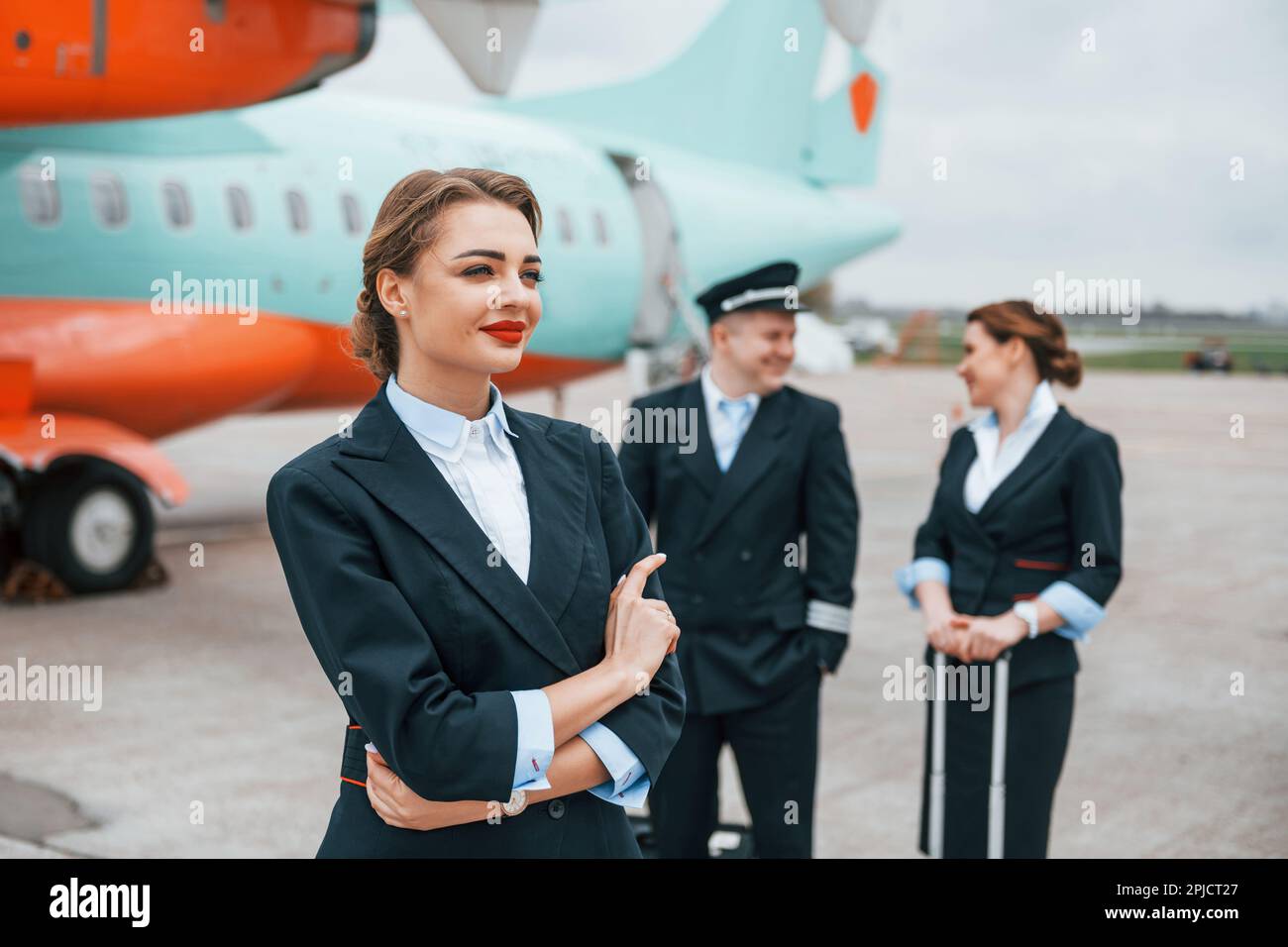 Aircraft crew in work uniform is together outdoors near plane Stock ...