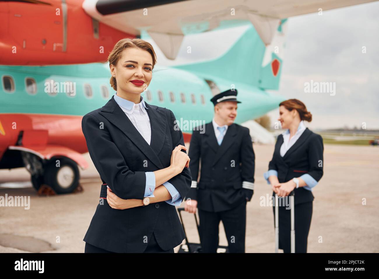 Aircraft crew in work uniform is together outdoors near plane Stock ...