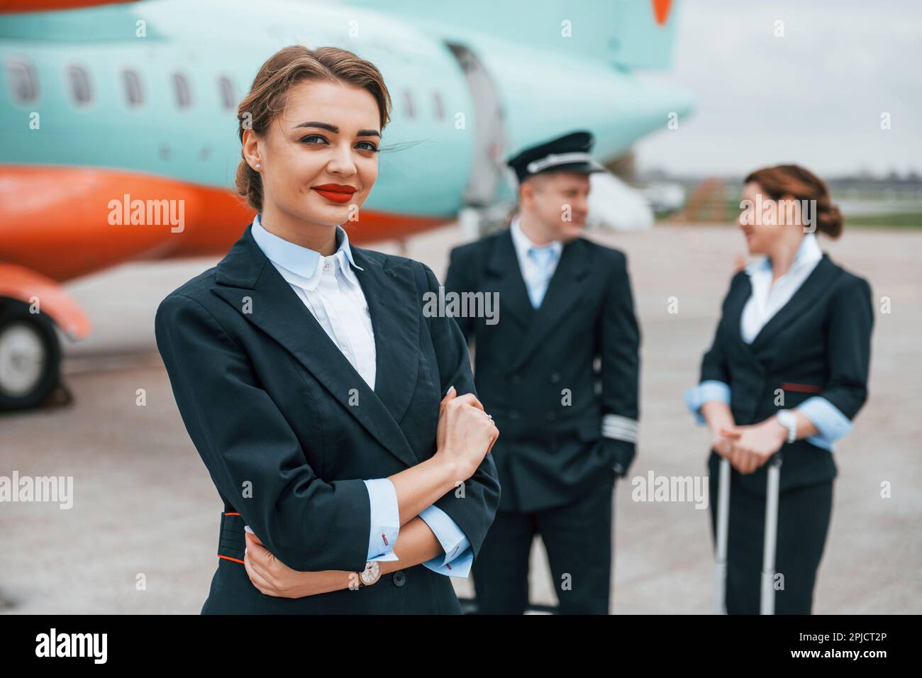 Aircraft crew in work uniform is together outdoors near plane Stock ...