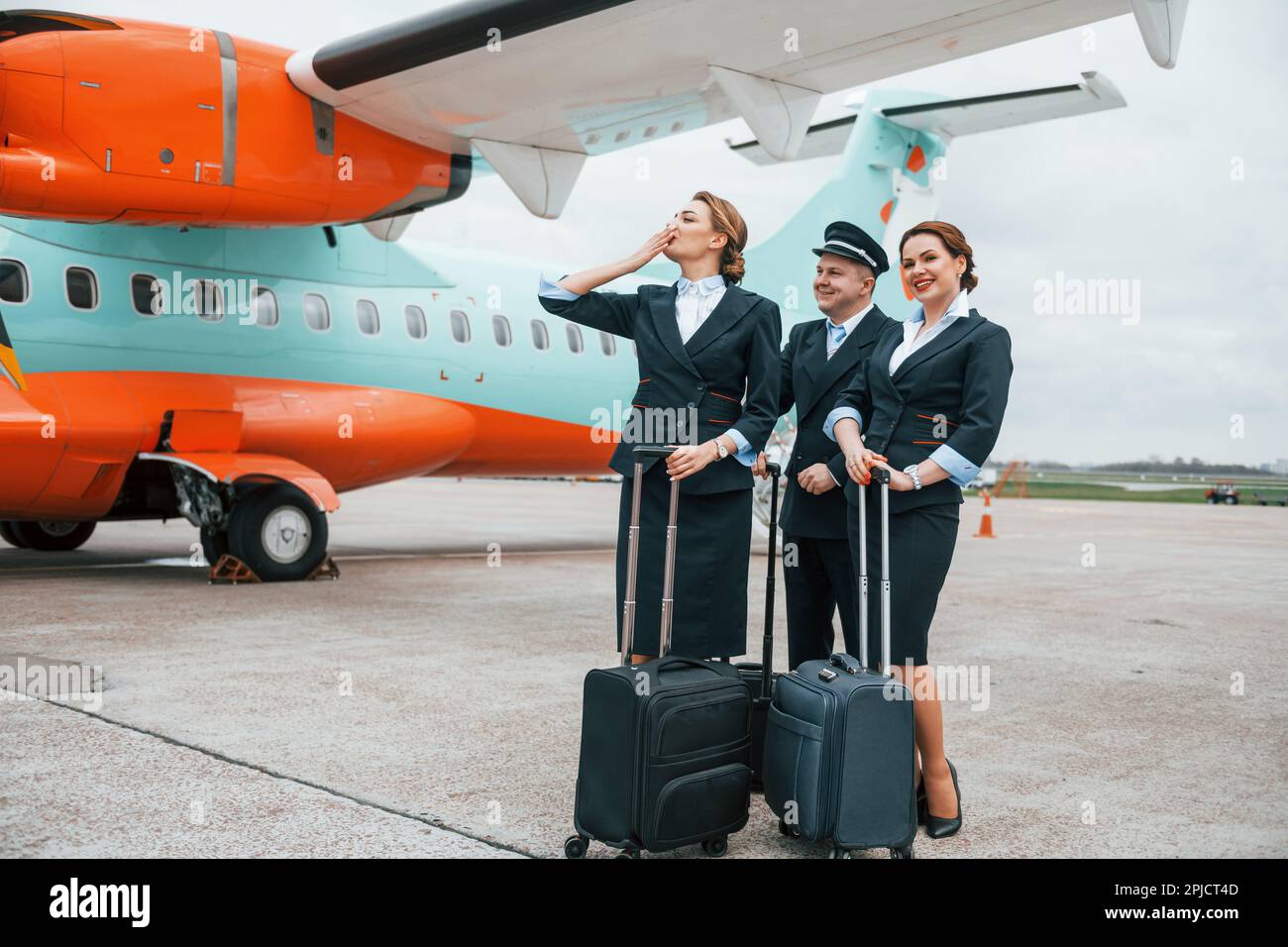 Aircraft crew in work uniform is together outdoors near plane Stock ...