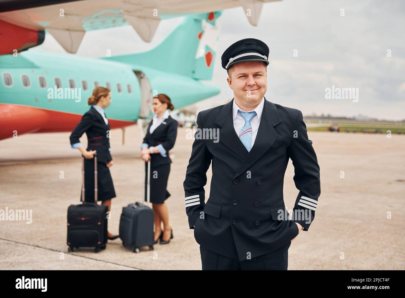 Aircraft crew in work uniform is together outdoors near plane Stock ...