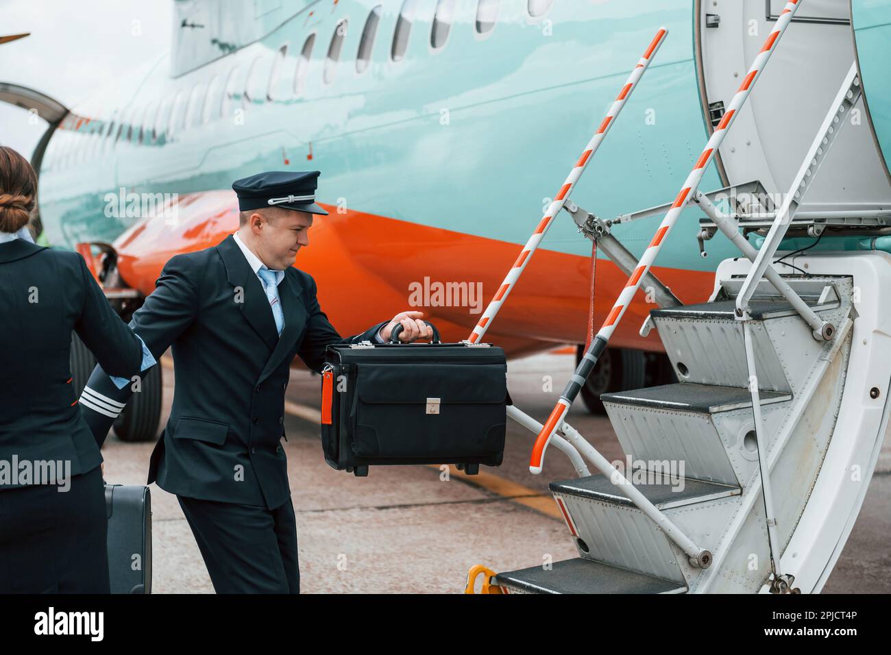 Aircraft crew in work uniform is together outdoors near plane Stock ...