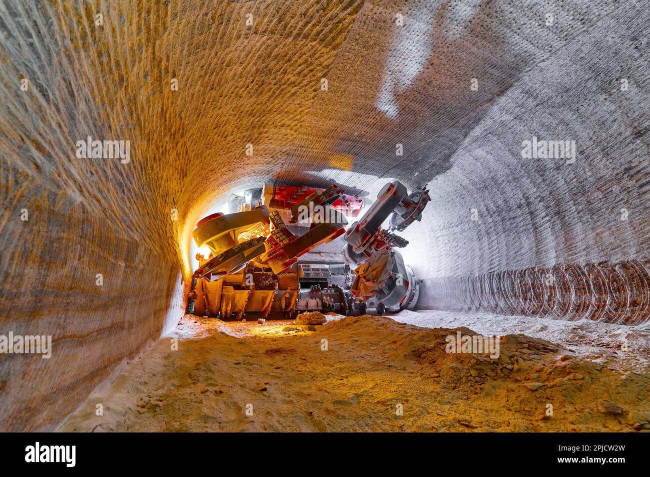Illuminated mining drilling machine in salt quarry tunnel Stock Photo ...