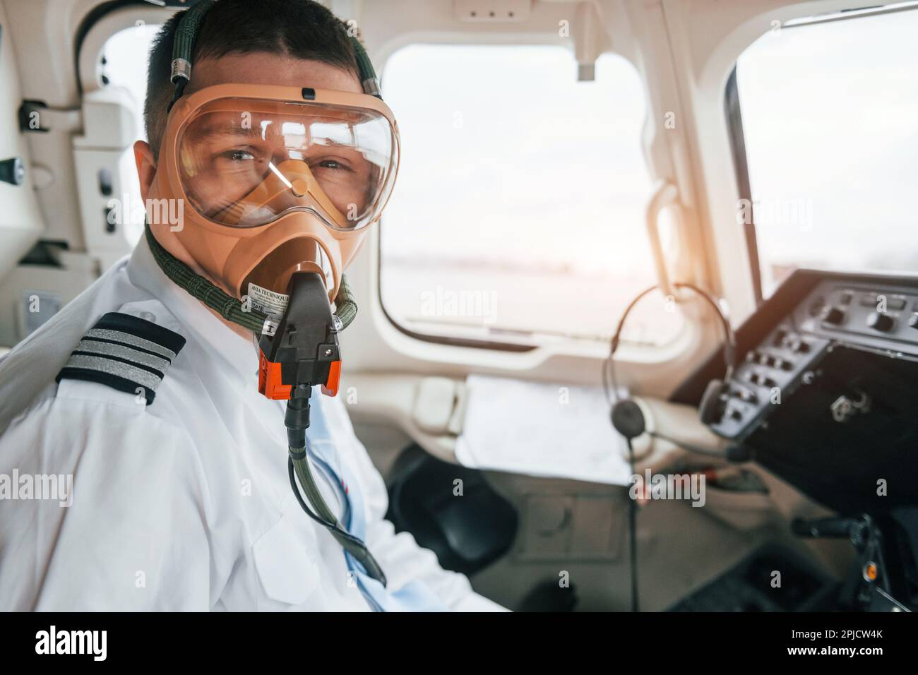 In oxygen mask. Pilot on the work in the passenger airplane. Preparing ...