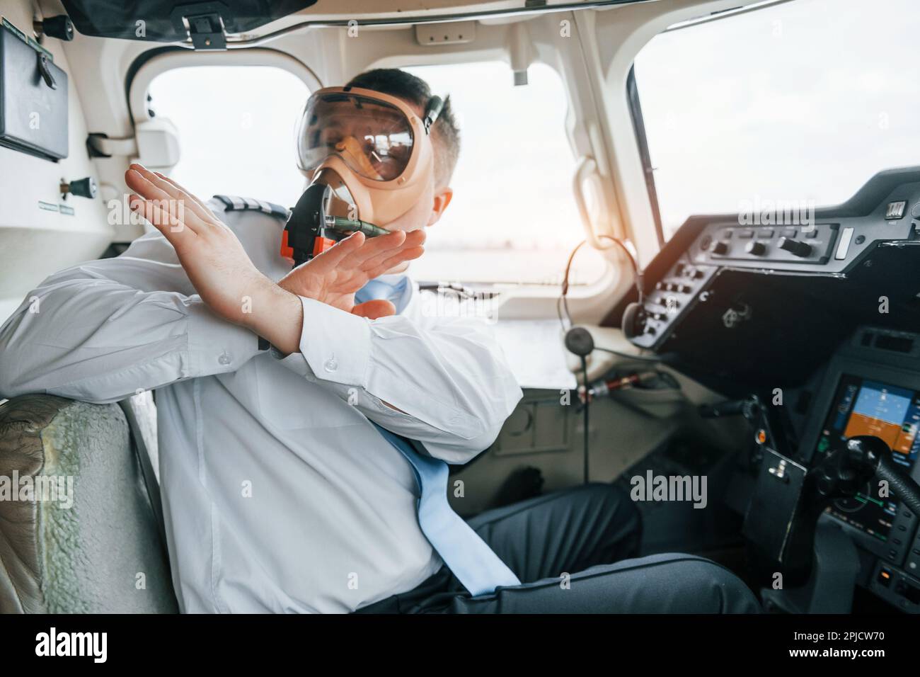 In oxygen mask. Pilot on the work in the passenger airplane. Preparing ...